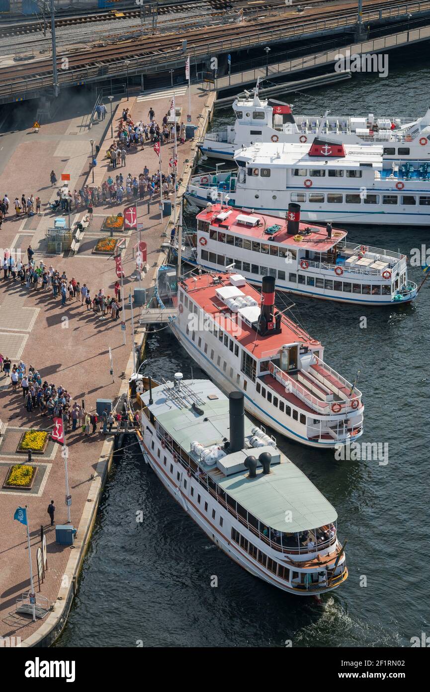 Passengers queue for Stomma tour boats on Stadshuskajen, Stockholm ...