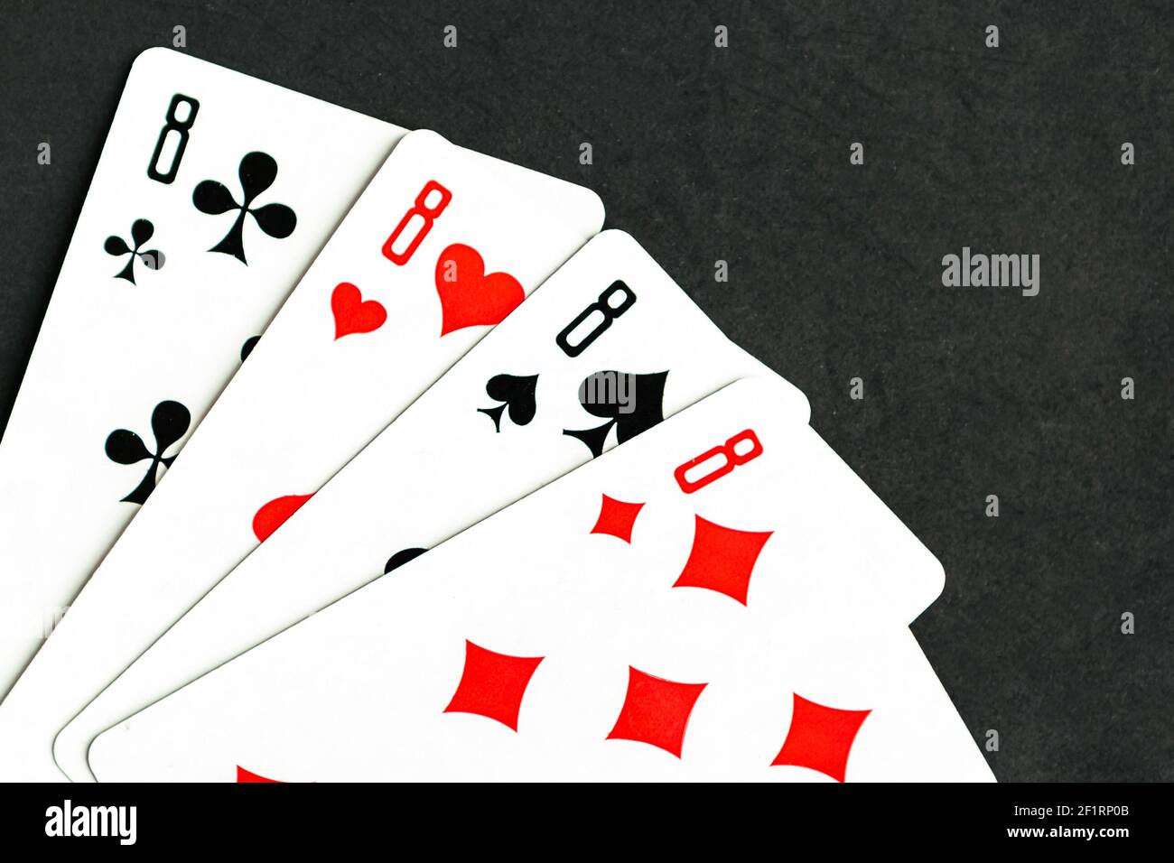 Poker quads playing card, black background, top view Stock Photo - Alamy