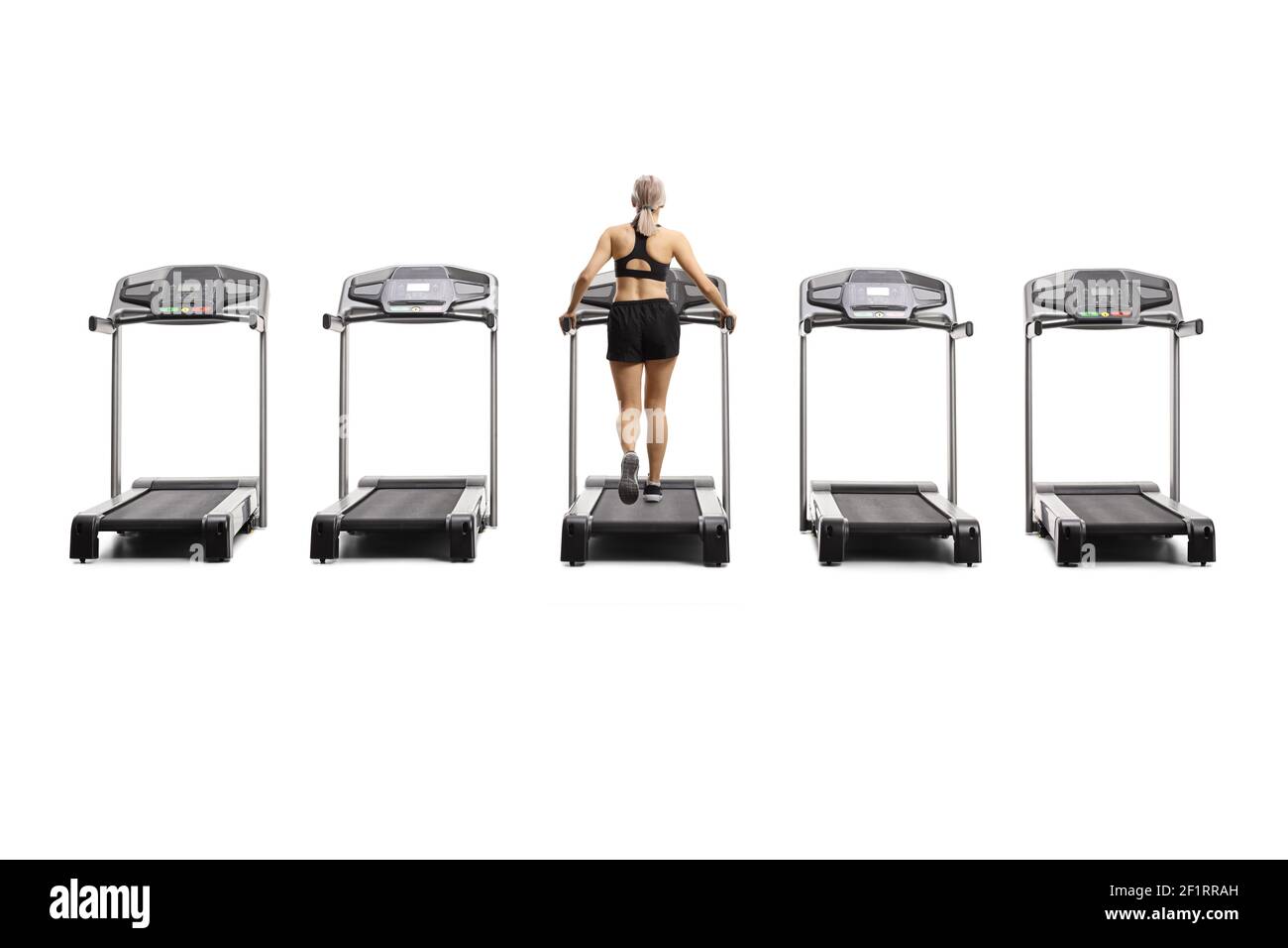 Full length rear shot of a young woman walking on a treadmill with ...
