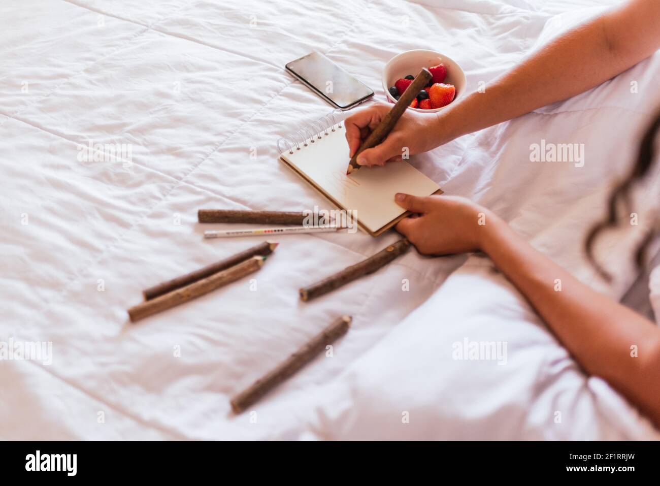 Stock photo of unrecognized girl writing notes in little notebook and ...