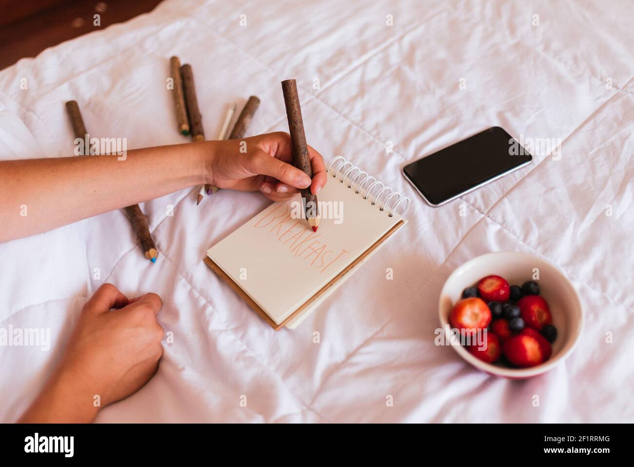 Stock photo of unrecognized girl writing notes in little notebook and ...