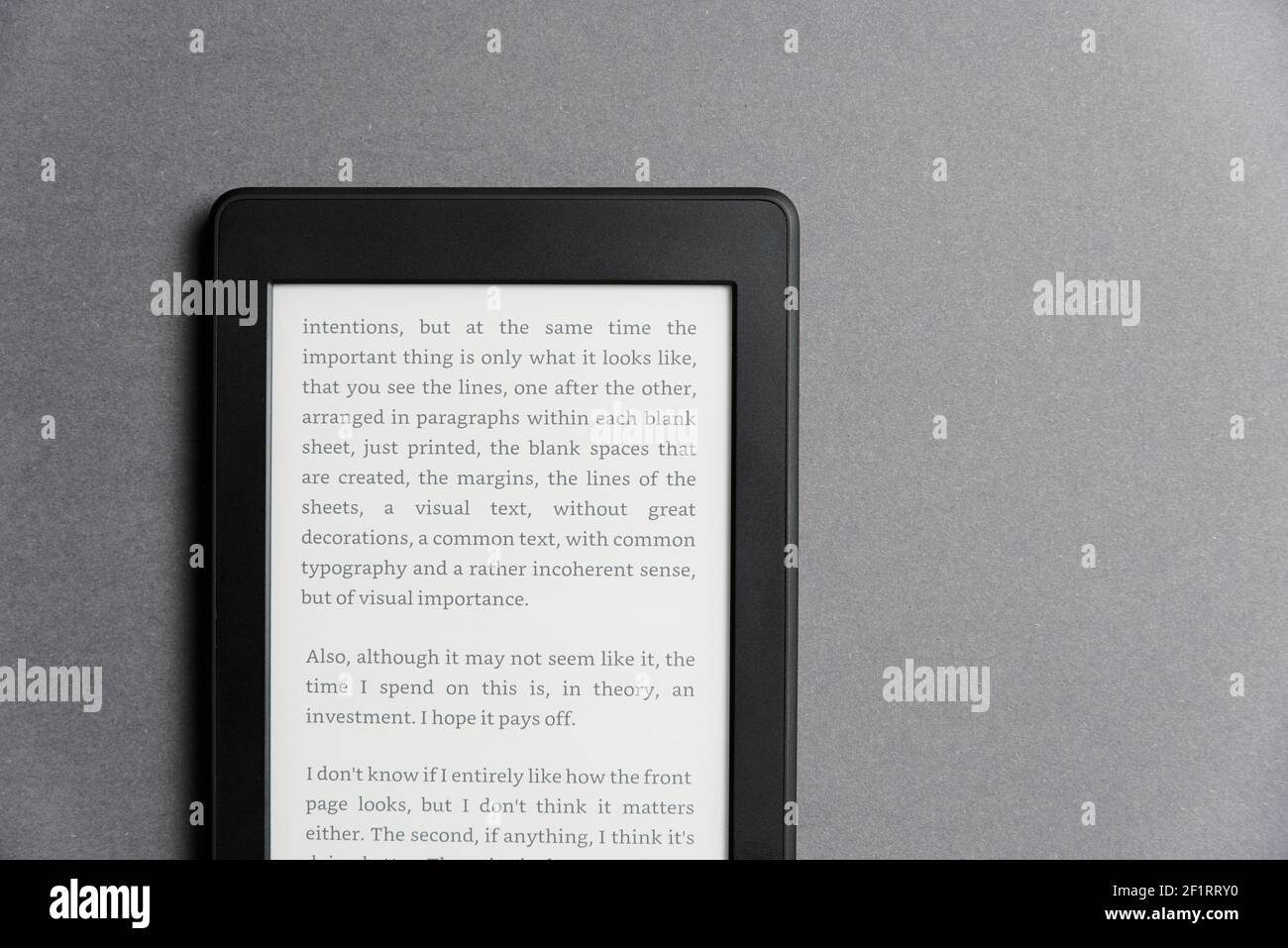 Closeup image of an electronic reader with text on the screen on a grey ...