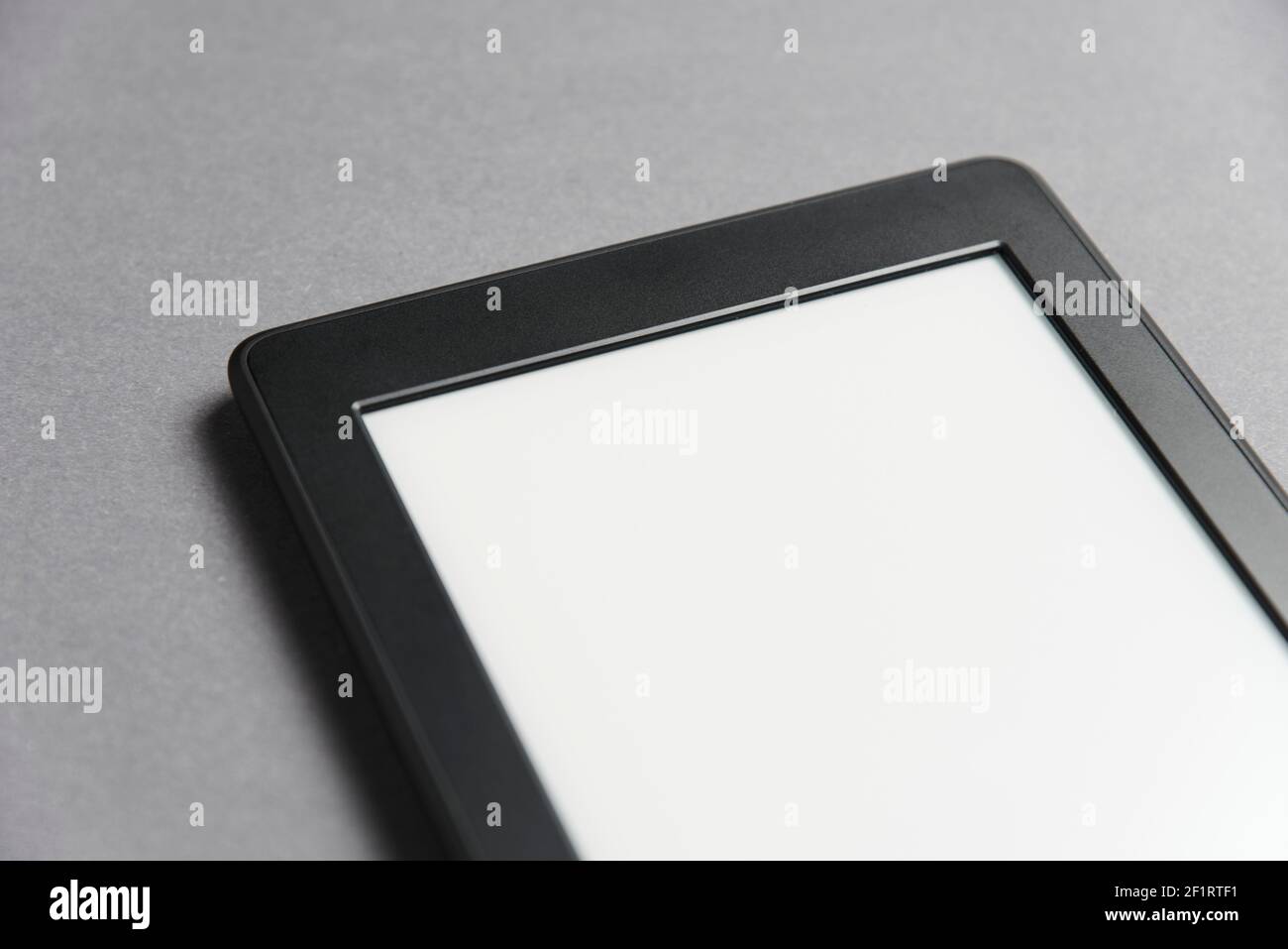Closeup image of an electronic reader with blank screen on a grey ...