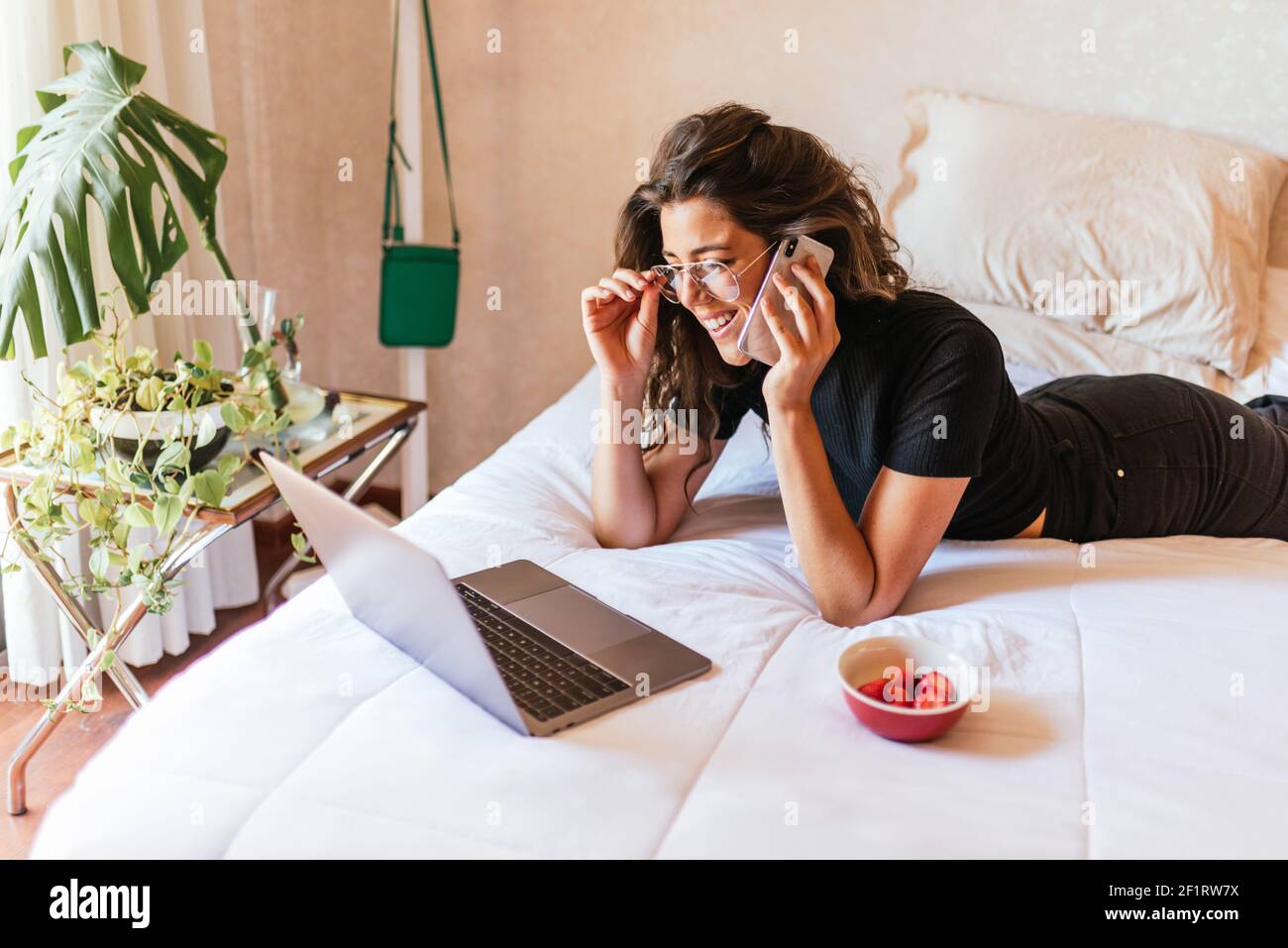 Stock photo of happy girl working with the computer in the bed and ...