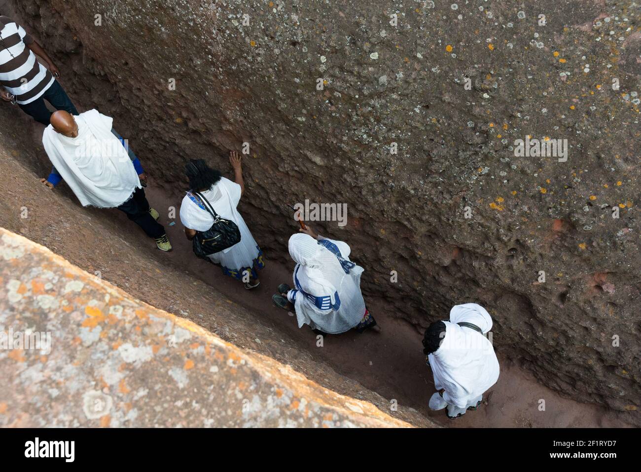 Pilgrims walkthrough a narrow passageway to visit The Church of Saint ...