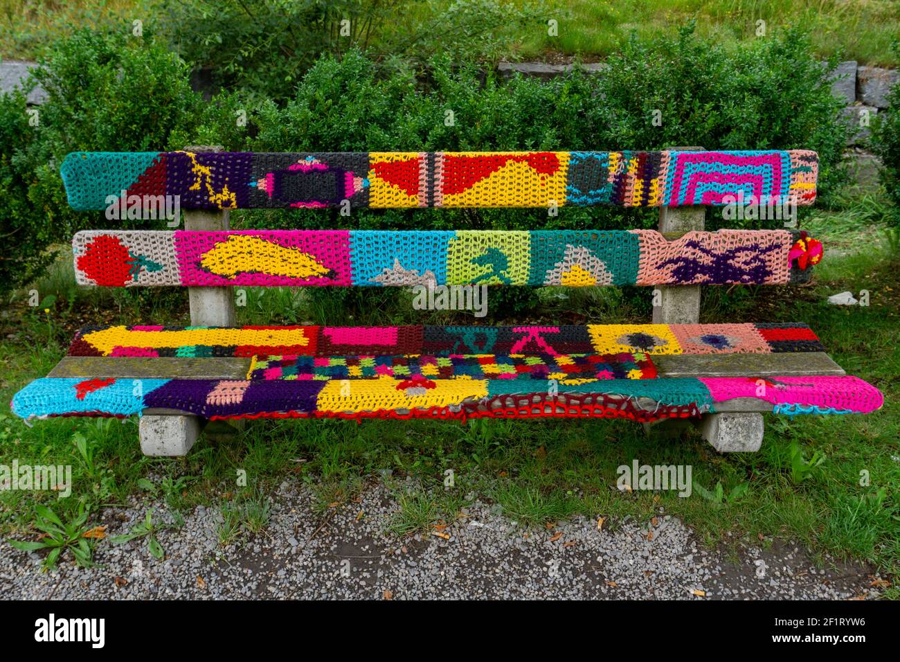 Colorful knitting covering a park bench Stock Photo - Alamy