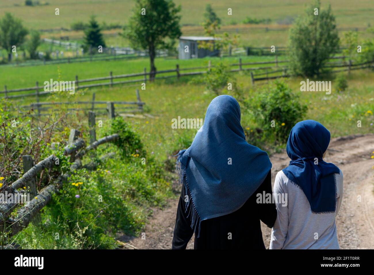 Two muslim girls walking on the rural mountain road with beautiful ...
