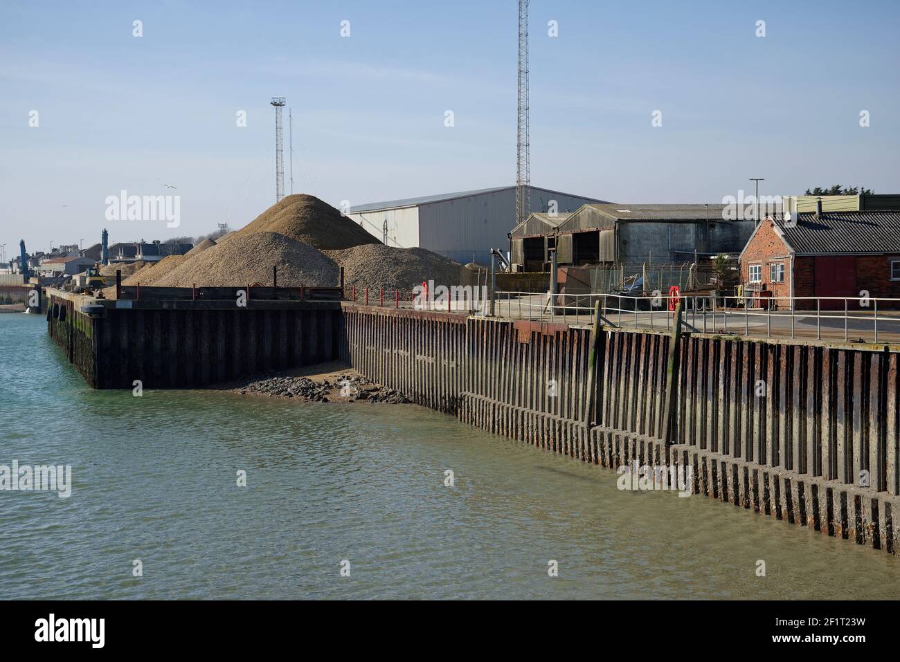 Edge of a port. Quayside frontage. Wooden vertical pillars, rubble and ...