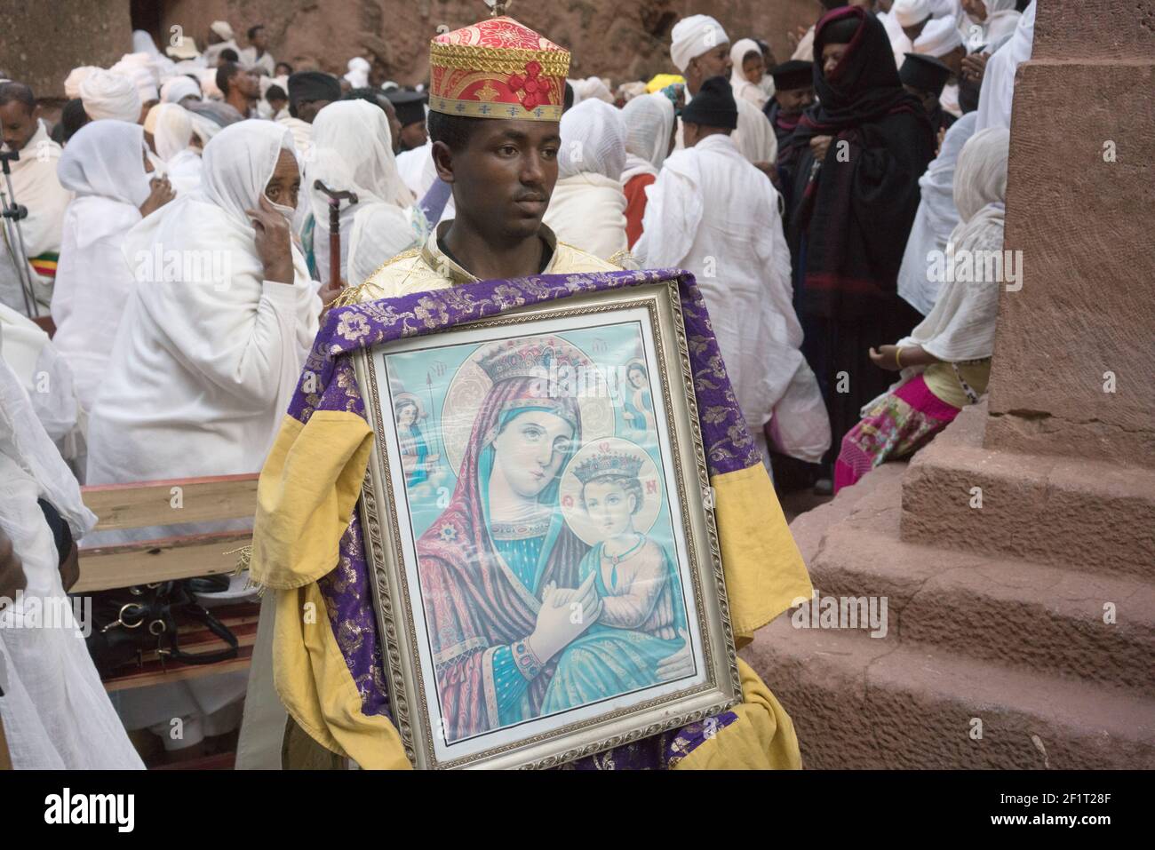 Deacon in a small procession carrying a likeness of Mary and Jesus at ...