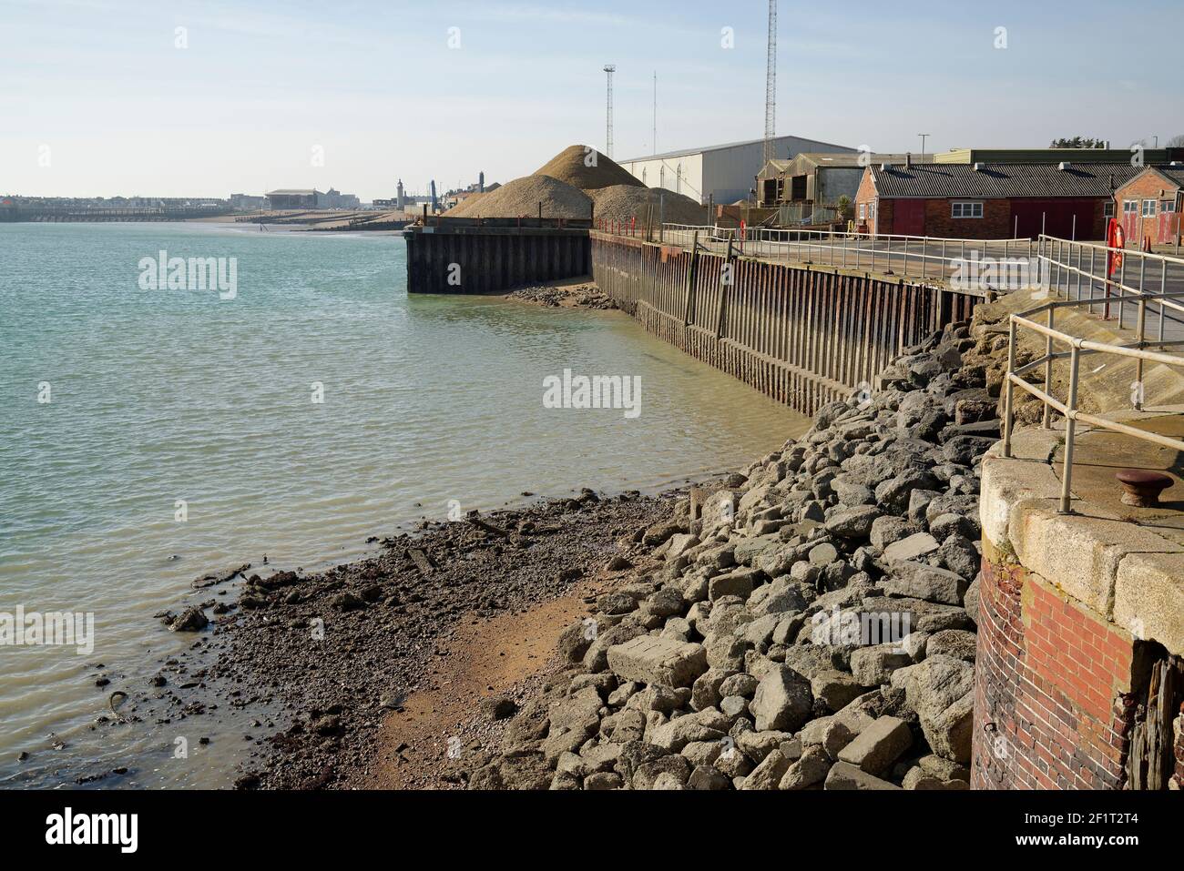 Edge of a port. Quayside frontage. Wooden vertical pillars, rubble and ...