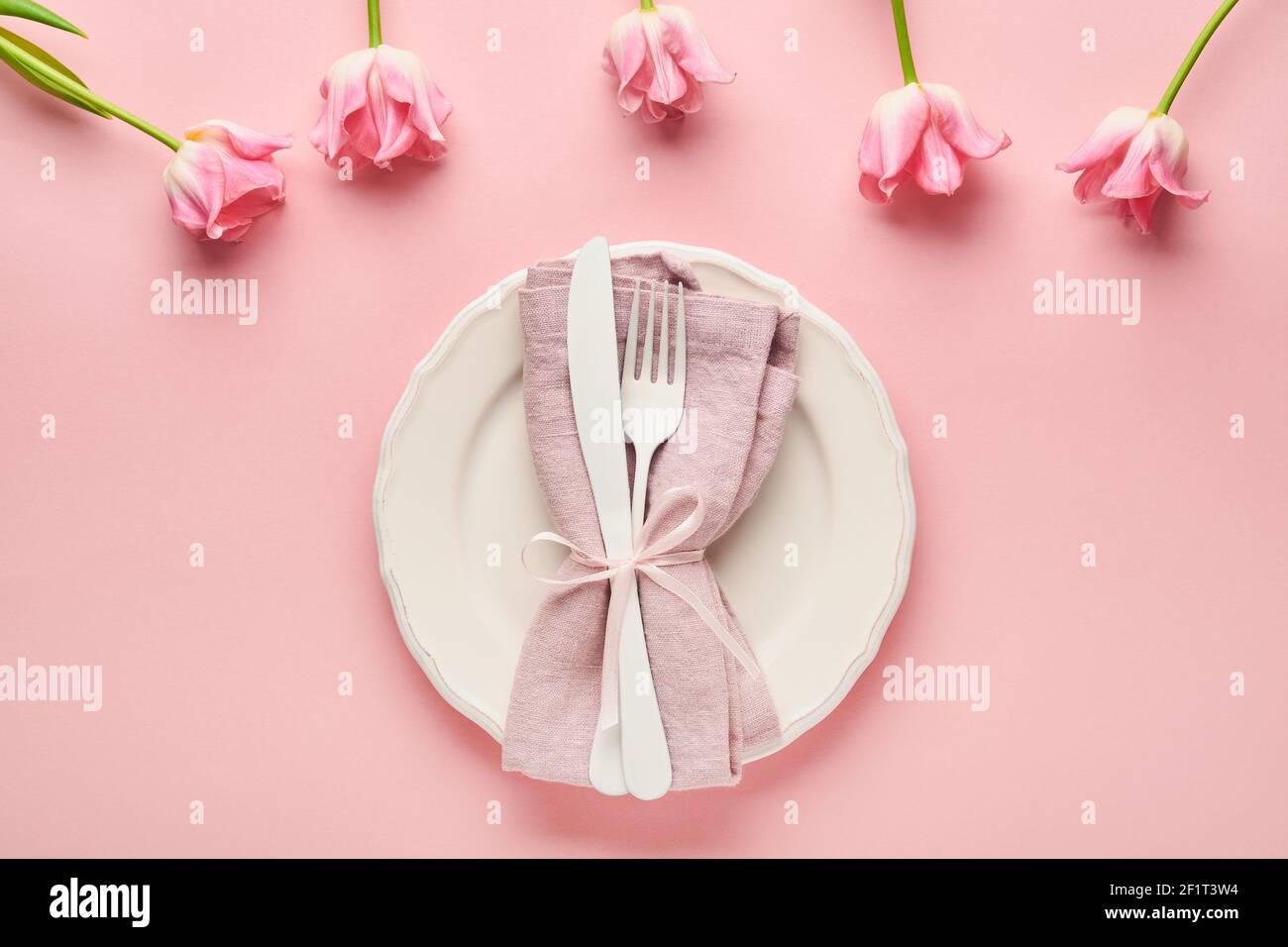 Easter table setting with floral decor on pink table. Elegance dinner ...