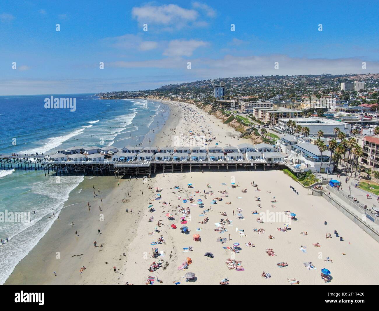 Aerial view of people at the beach with the pier with during blue day ...