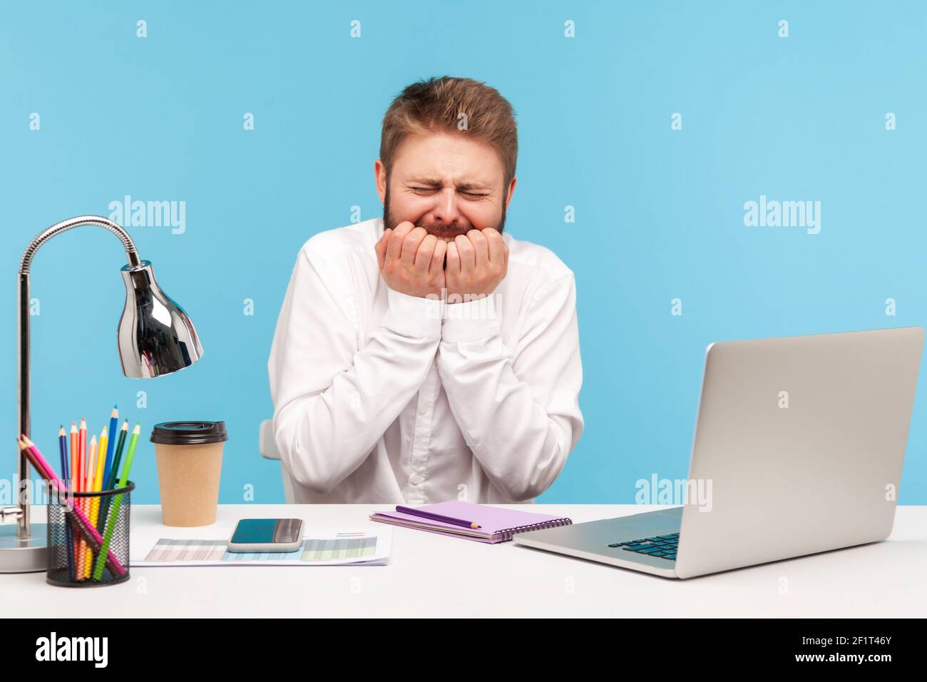 Nervous anxiety man office worker biting his nails in panic sitting at ...