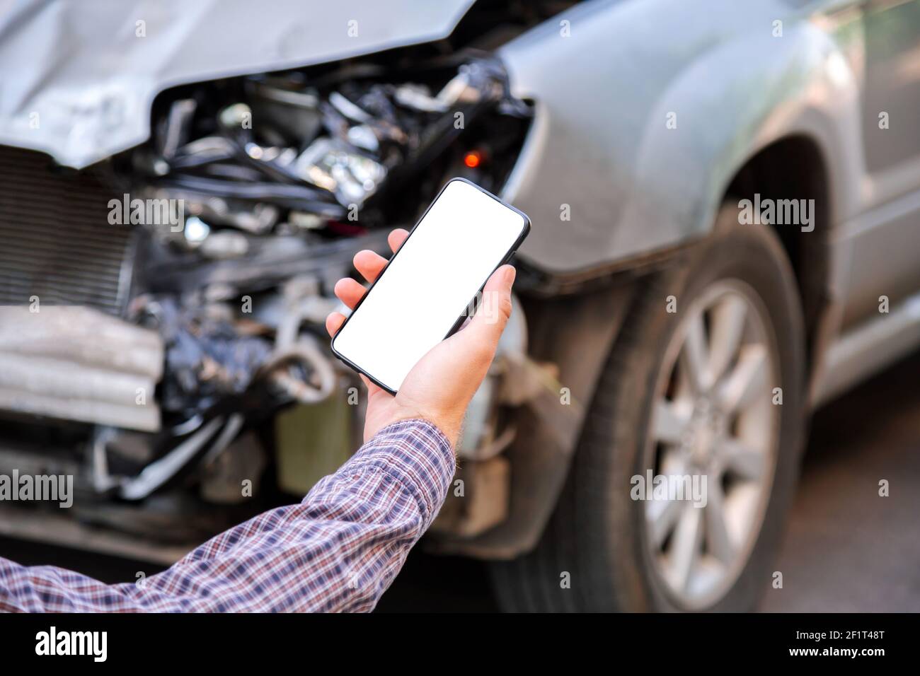 Man holds mockup mobile white phone screen in hands after car accident ...