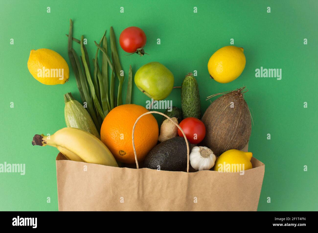 Paper bag of vegetables and fruits on the green background. Bag food ...