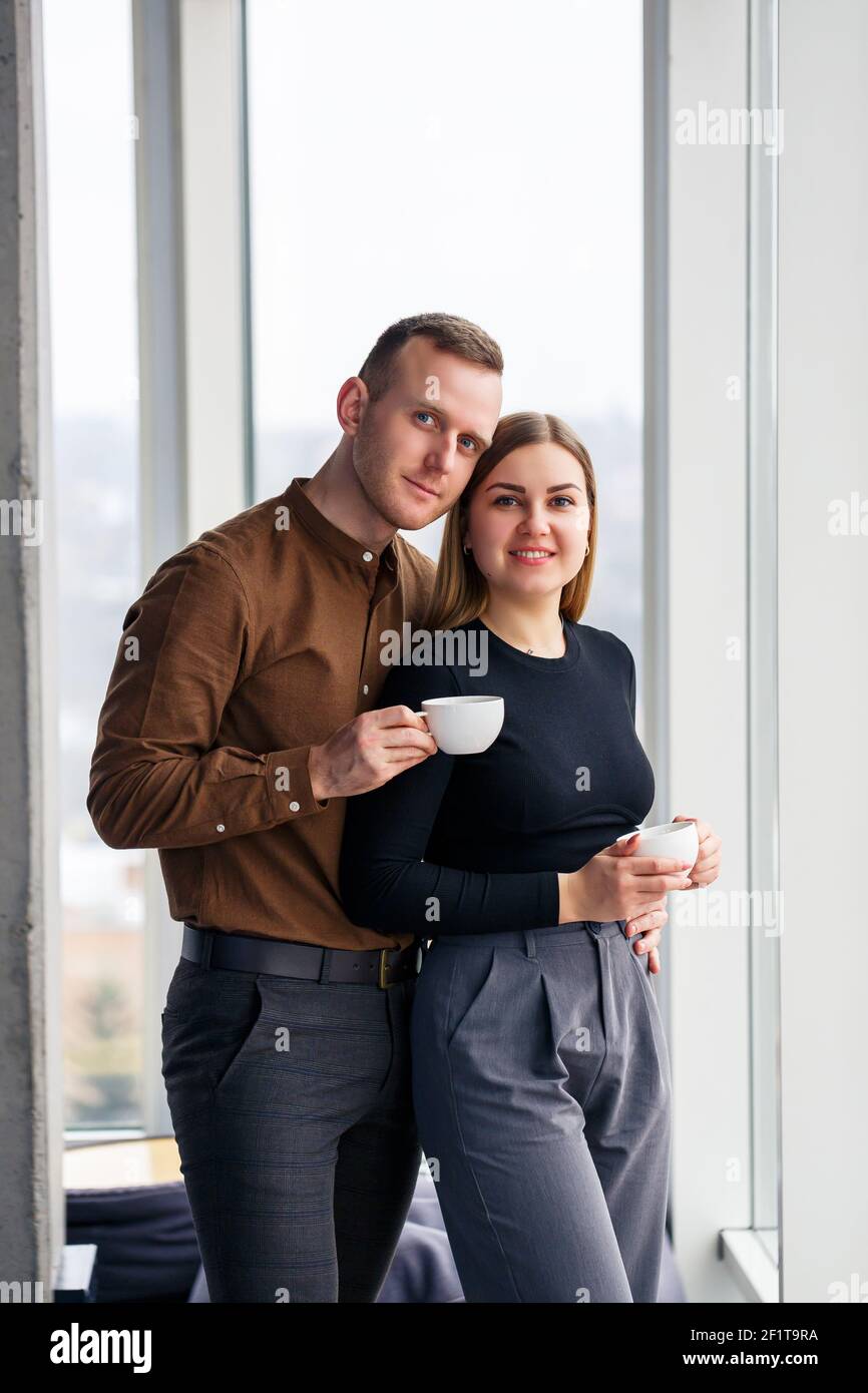Stylish young couple in love in front of large panoramic windows. Young ...