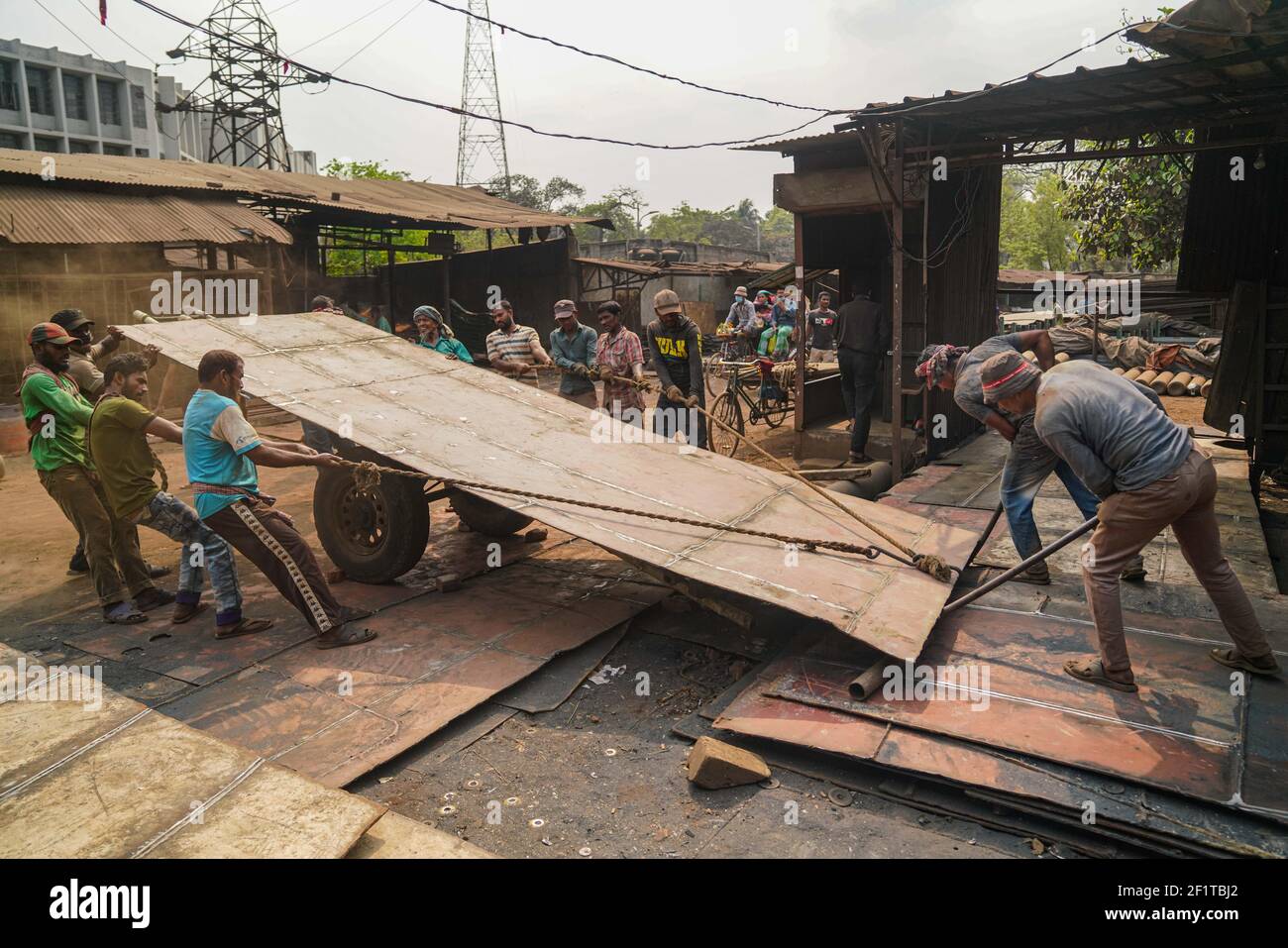 Workers carrying a steel structures at a workshop in Dhaka, Bangladesh ...
