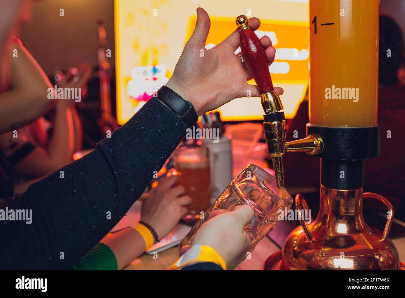 The male bartender pouring beer into a glass close-up. Street food. A ...
