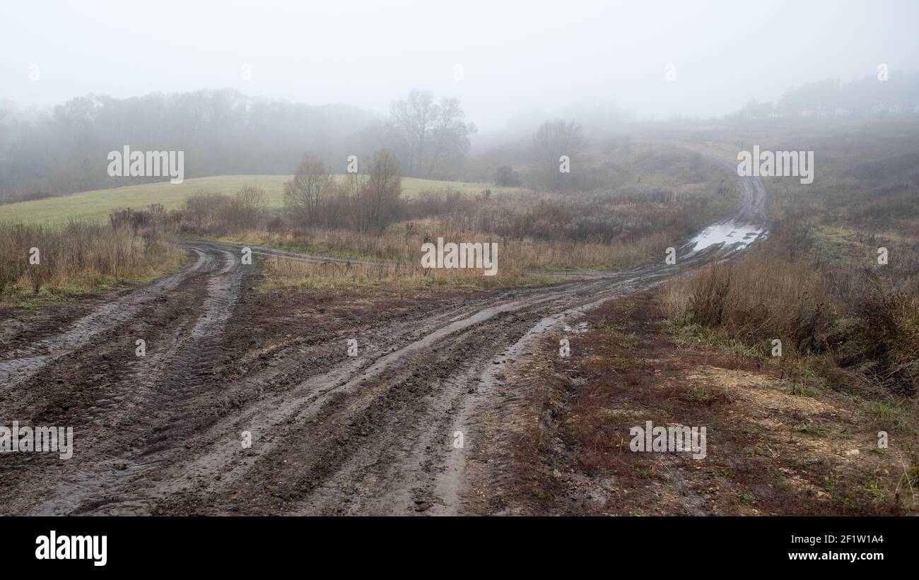 Dirty rural road in black earth in mist landscape panorama Stock Photo ...