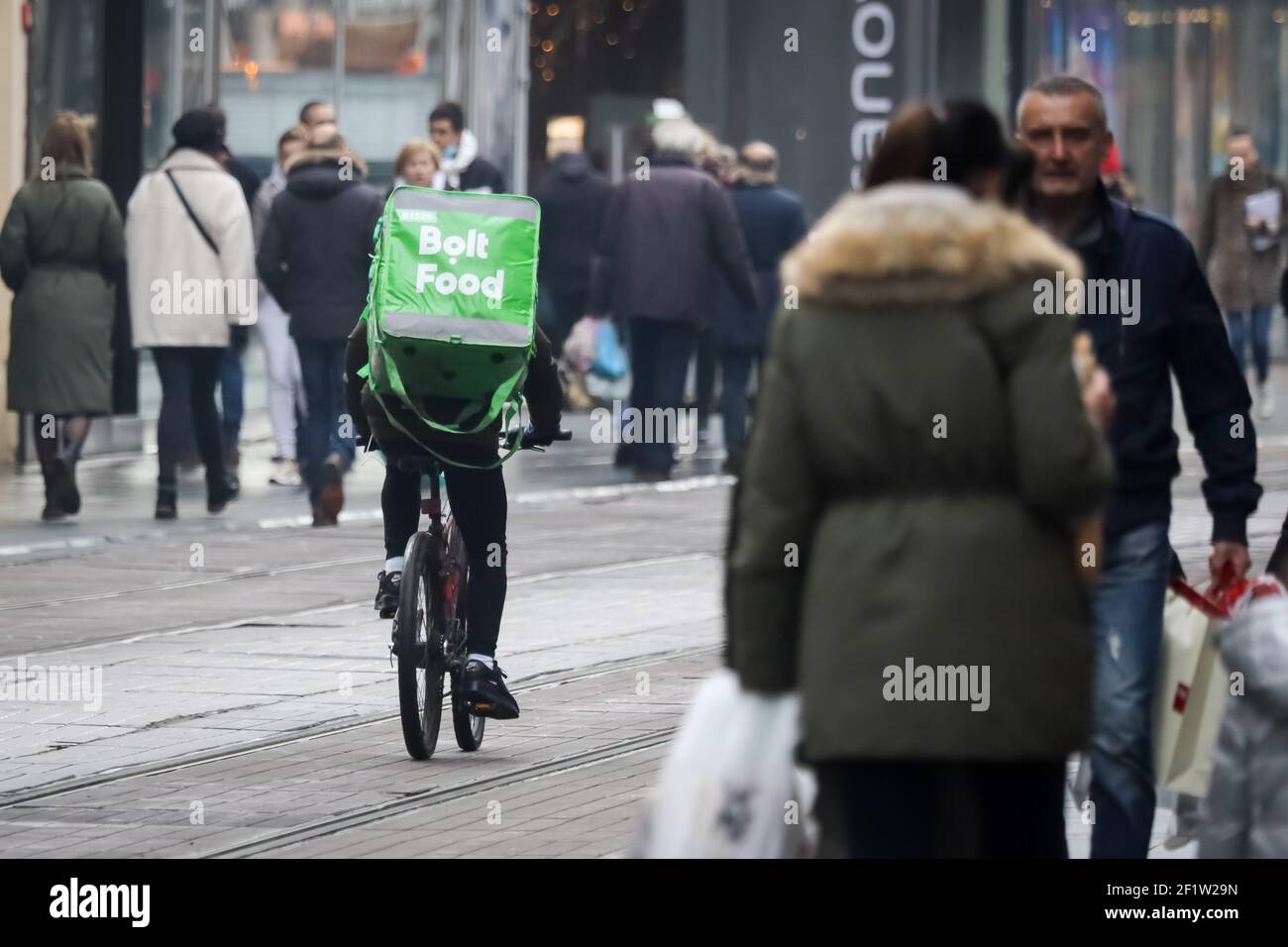 A Bolt Food delivery man driving a bicycle to deliver food from the ...
