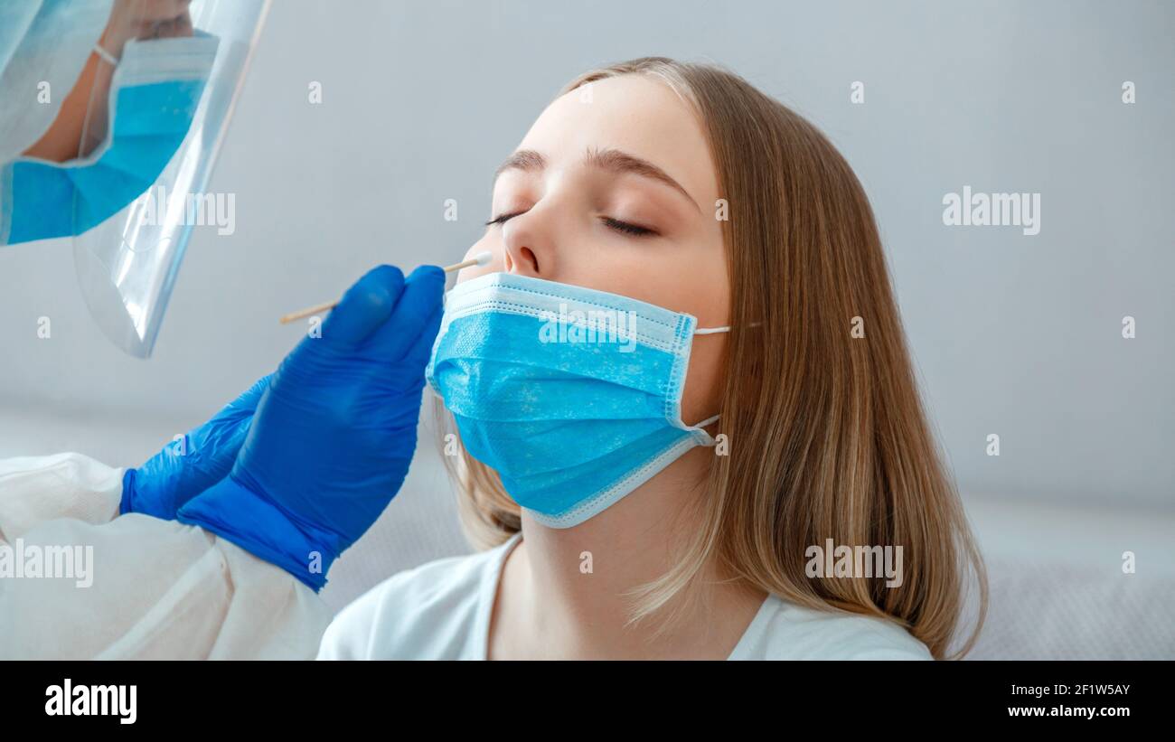 Doctor taking nasopharyngeal culture, PCR test to woman patient. Nurse ...