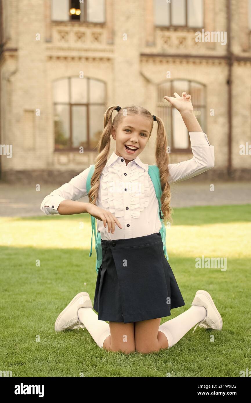 Carefree student. Smiling pupil sit on grass. Have fun. Happy kid ...