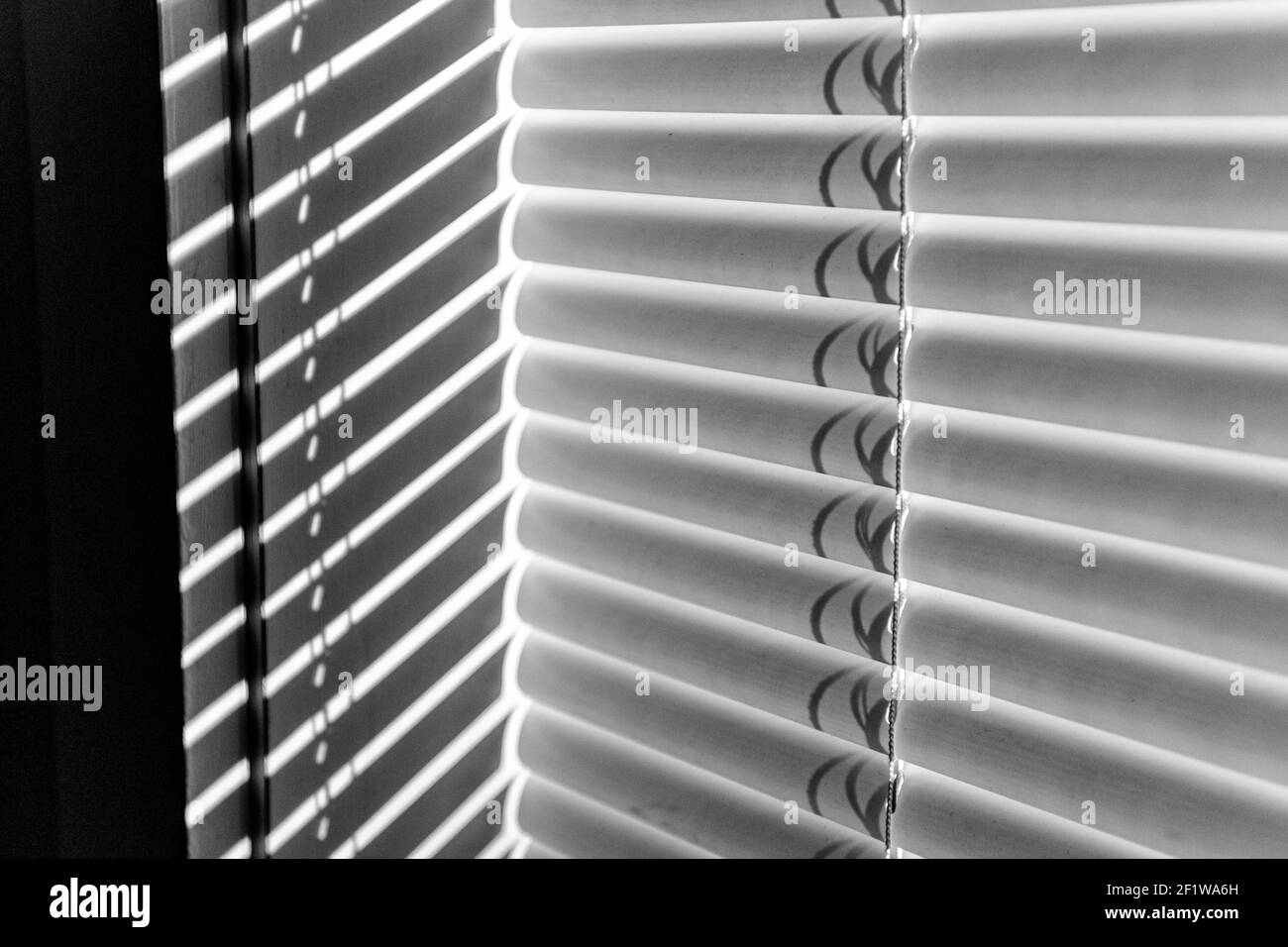 Sunlight filtered through Venetian blinds creates gentle shading and ...
