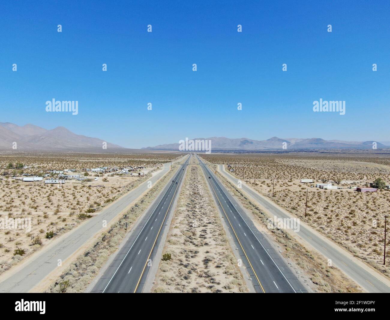 Aerial view of road in the middle of the desert under blue sky in ...