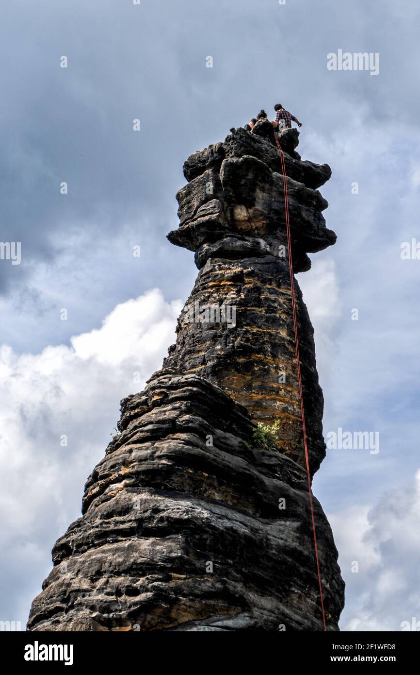 Rock climbers on top of a rock pillar in the Elbsandstone mountains in ...