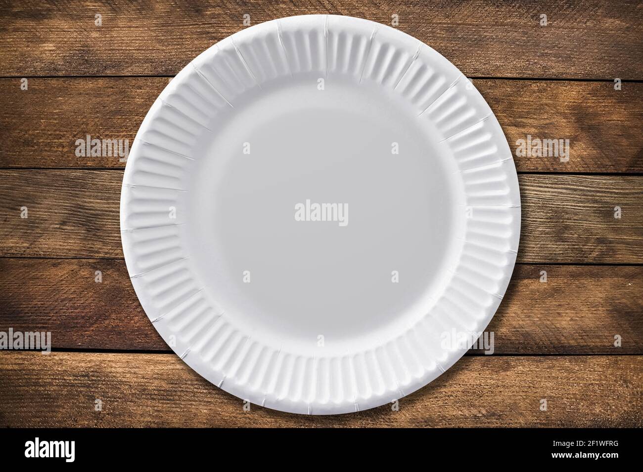 Disposable paper plate on a wooden background. Empty white cardboard ...