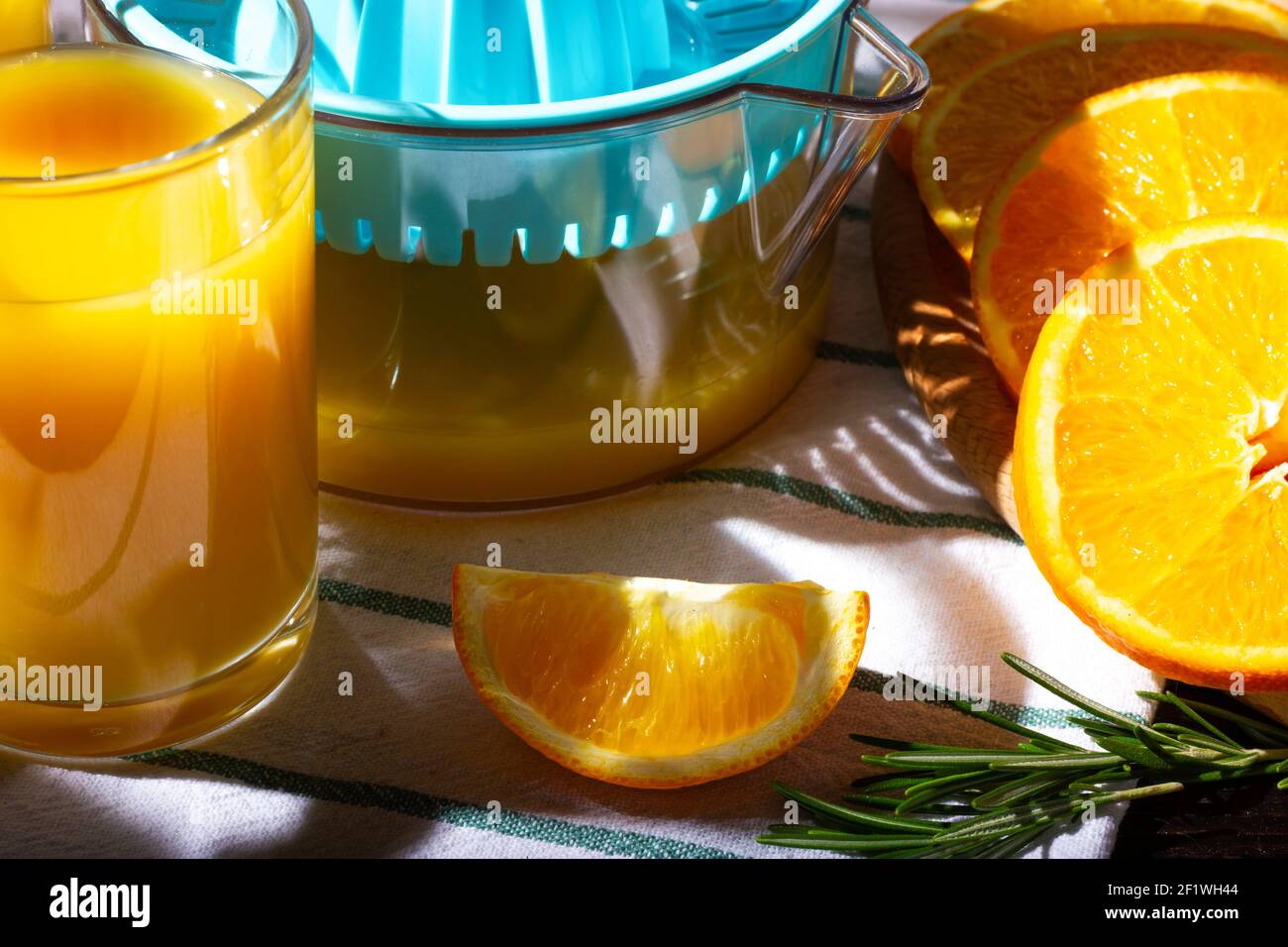 The process of making orange juice. Orange fresh juice in a juicer. A ...