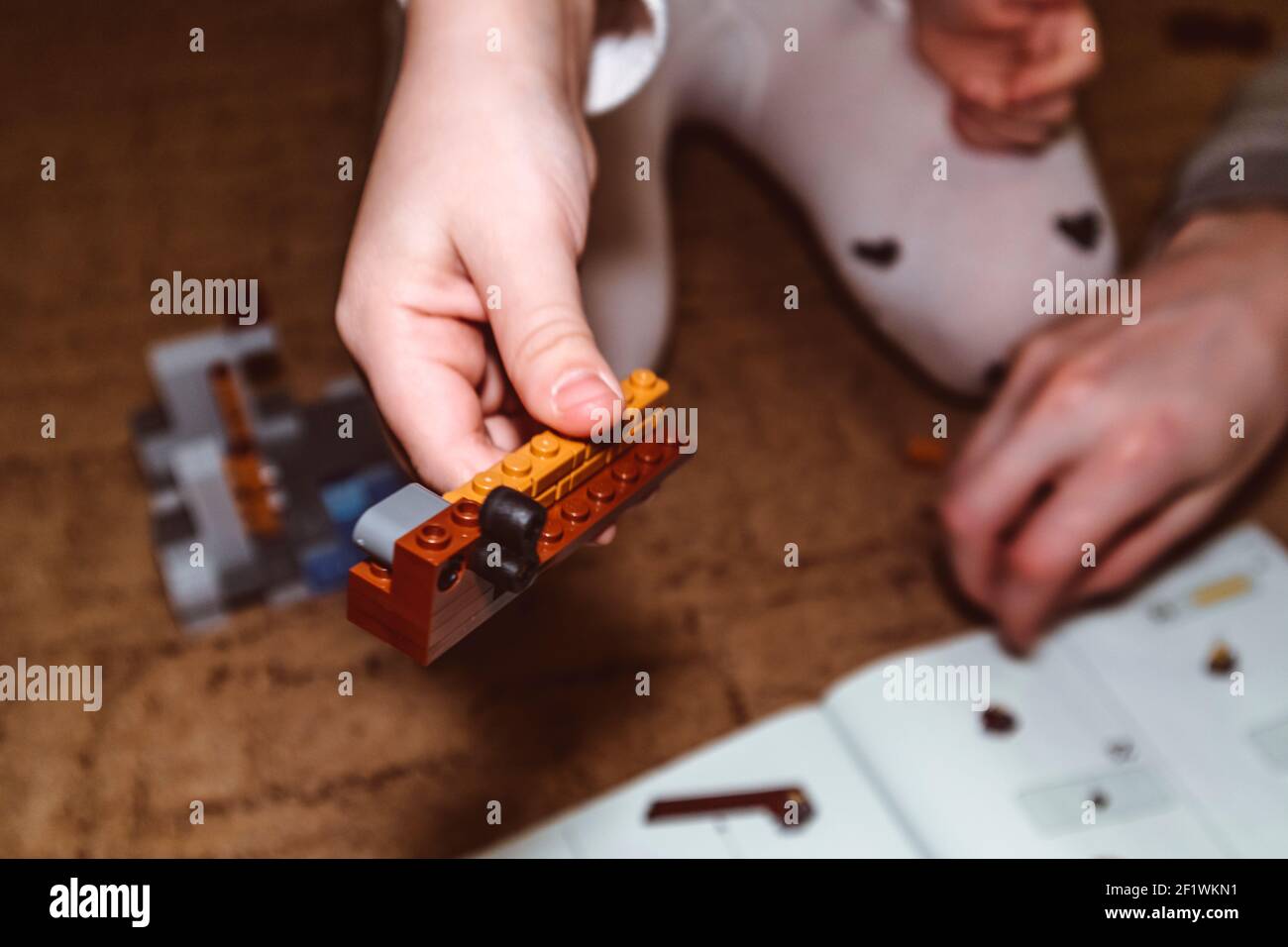 Baby girl and parent father assemble construction set house toys Stock ...