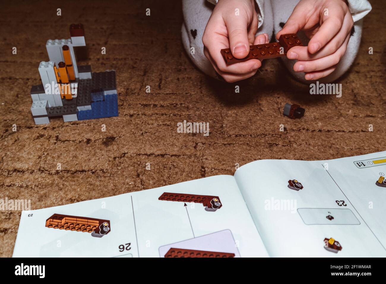 Baby girl and parent father assemble construction set house toys Stock ...