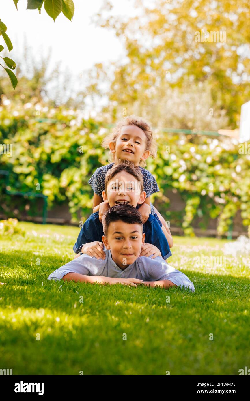 Portrait of three little children as a tower Stock Photo - Alamy
