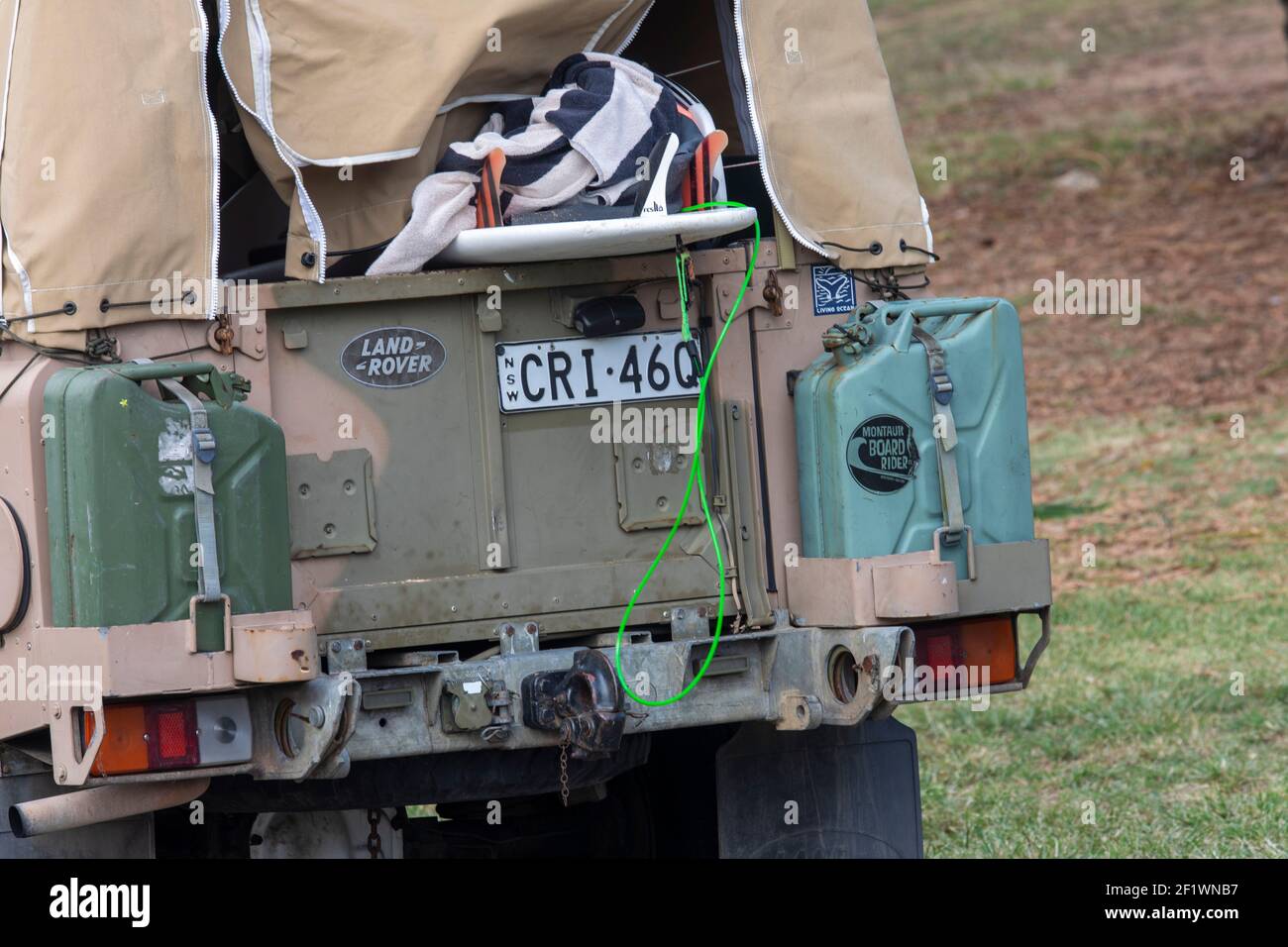 Land Rover Defender vehicle in army khaki colours with surfboard stored ...