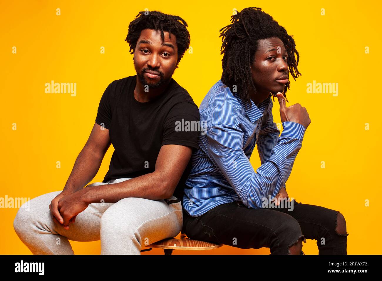 two african american guys posing cheerful together on yellow background ...