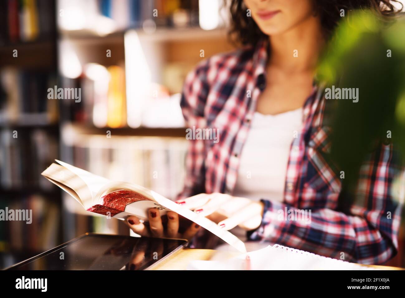 Close up of hardworking student girl reading book in the library Stock ...
