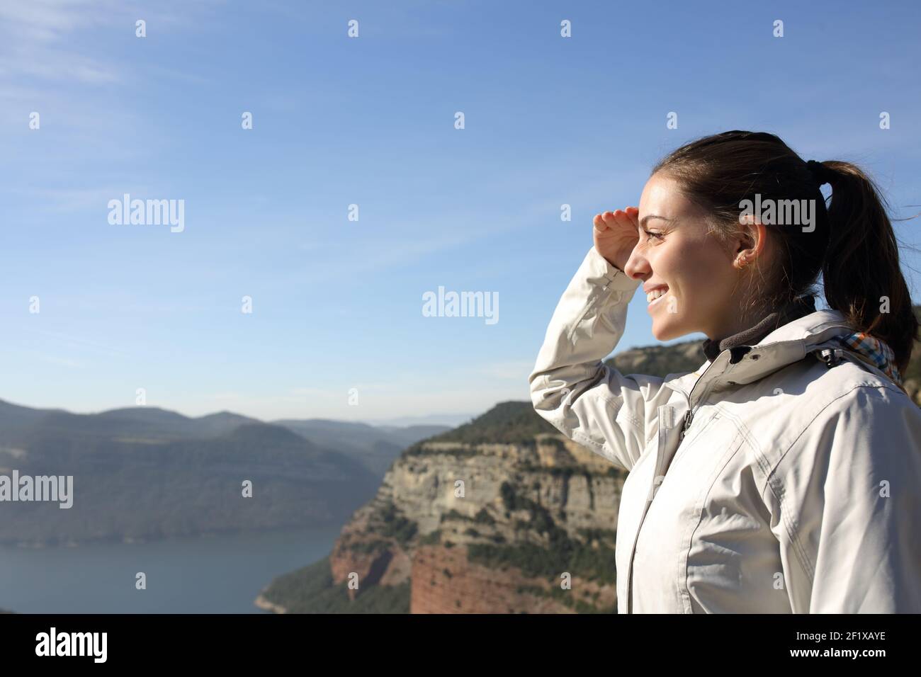 Side view portrait of a happy trekker contemplating views with hand on ...