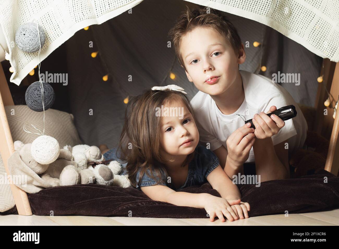 Siblings In A Hut Of Chairs And Blankets Brother And Sister Playing At