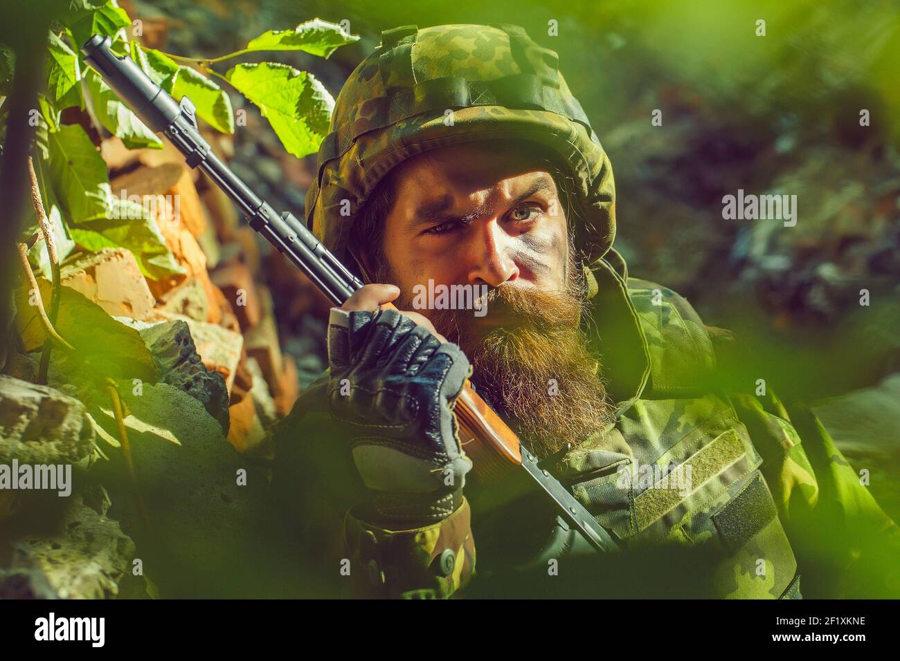 Soldier with sad face in military helmet and camouflage with gun on ...