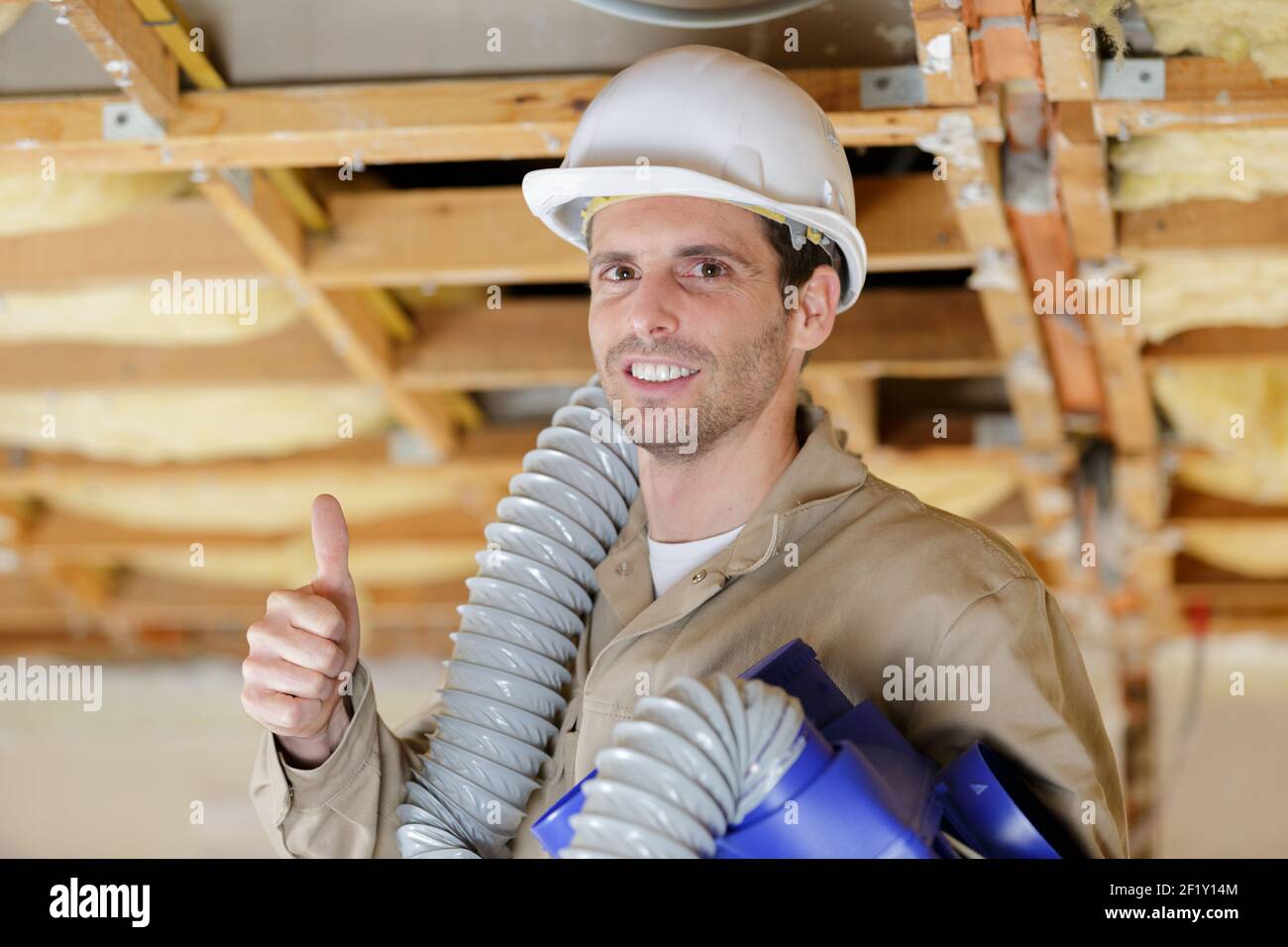 worker in the attic connects metal air ducts Stock Photo - Alamy
