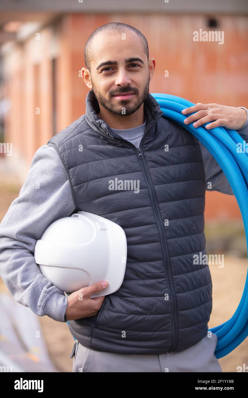 construction worker on site holding pipe Stock Photo - Alamy