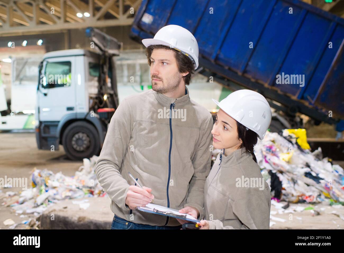 workers in a recycle center lorry tipping in background Stock Photo - Alamy