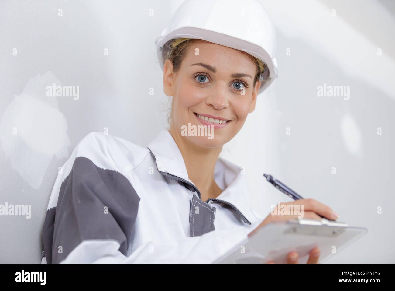 portrait of female builder writing on clipboard Stock Photo - Alamy