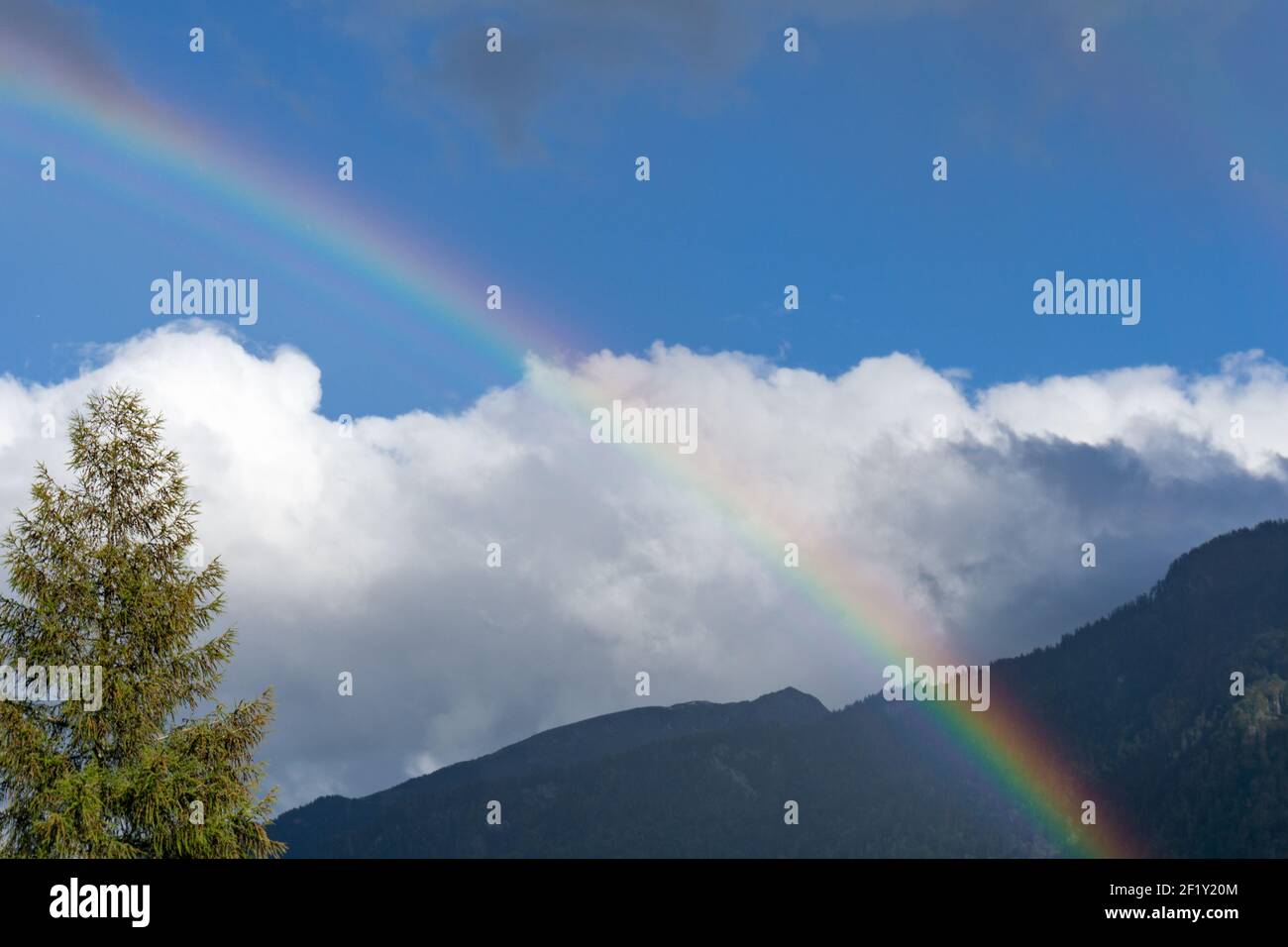Rainbow in mountain landscape with blue sky and white clouds Stock ...