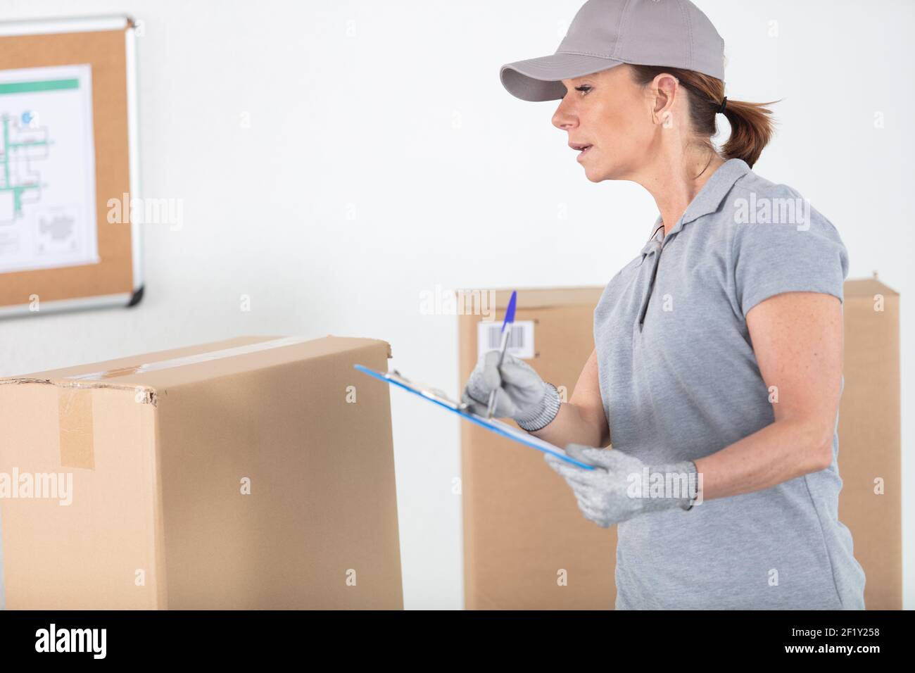 delivery person delivering packages holding clipboard Stock Photo - Alamy