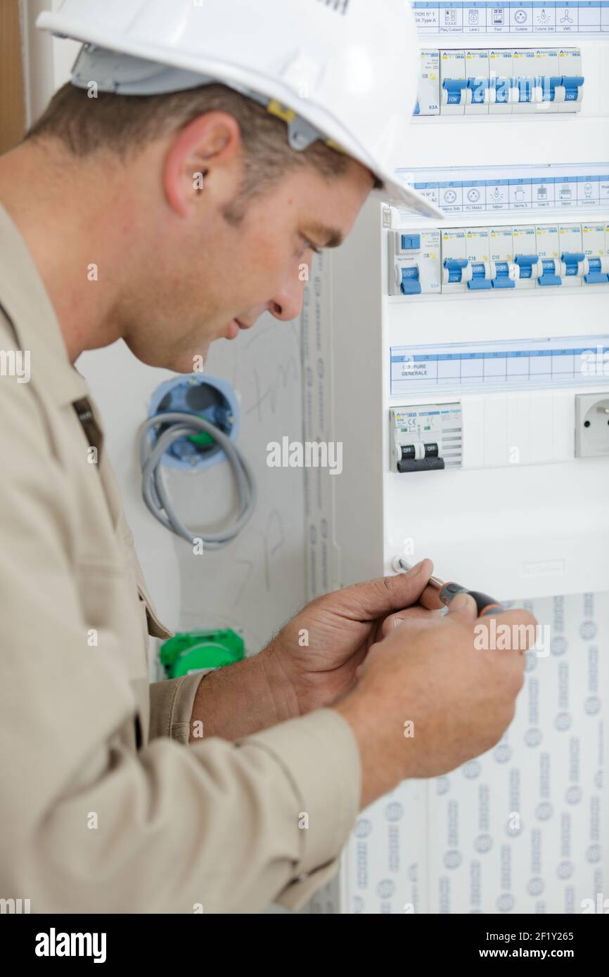 electrician working in fuse board Stock Photo - Alamy