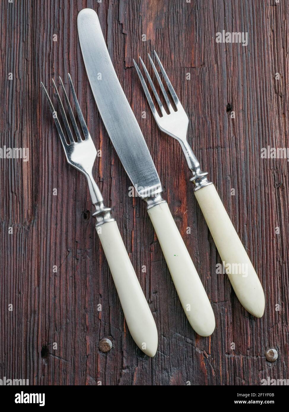 Vintage forks and knife on old wooden texture. Close up top down view ...