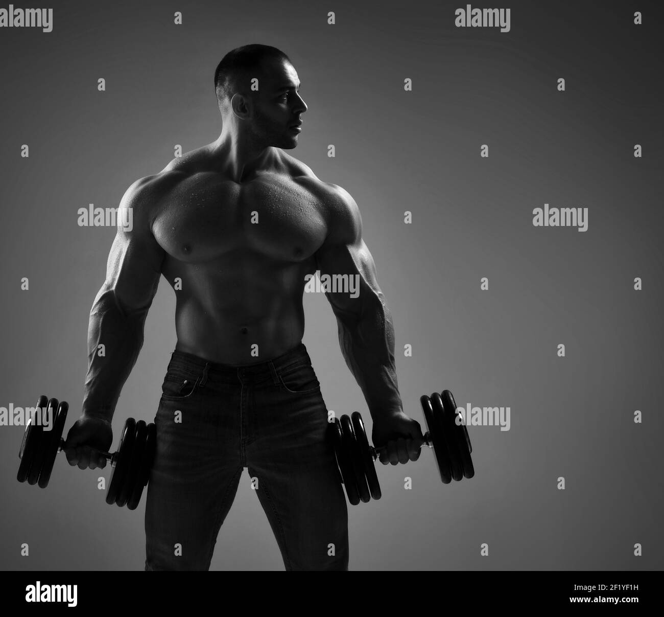 Portrait of a muscular strong well built men bodybuilder holding ...