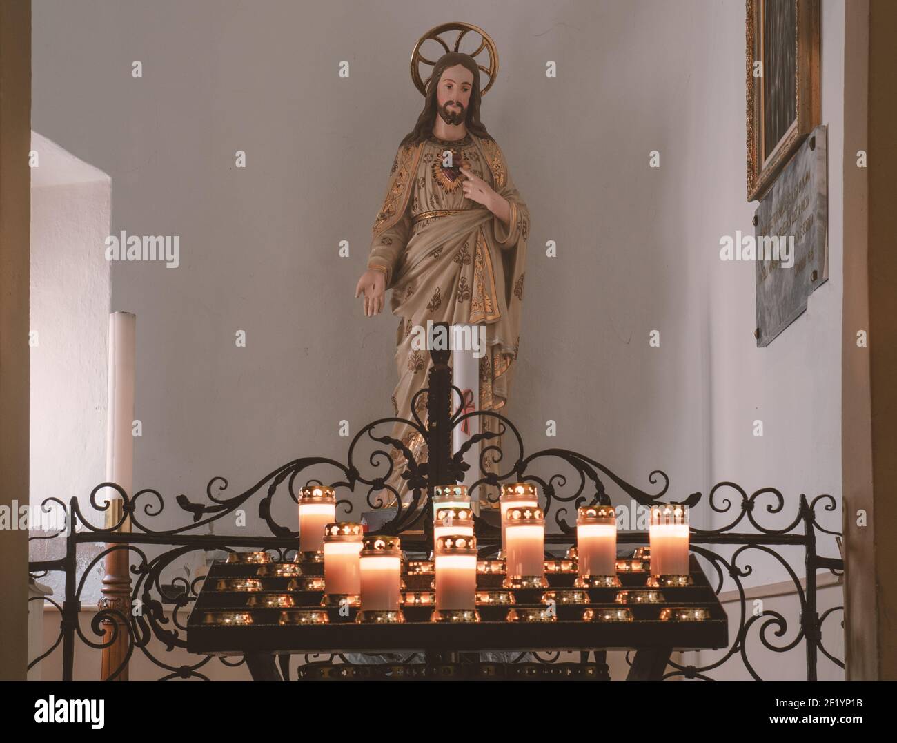 burning candles in front of the statue of Jesus in the church Stock ...